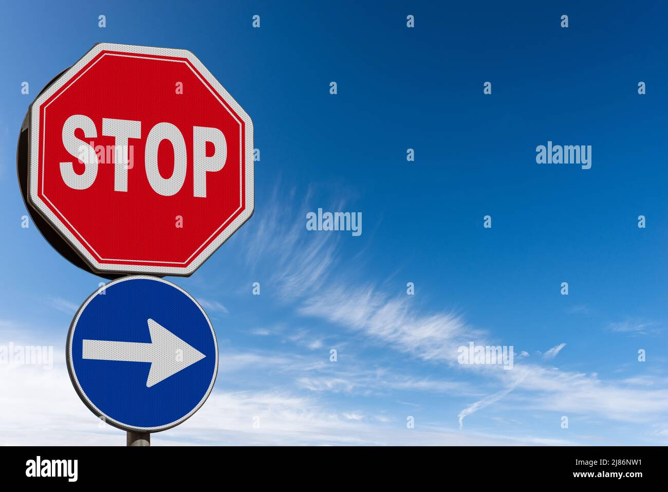 Close-up of a one way and a stop road sign against a clear blue sky ...