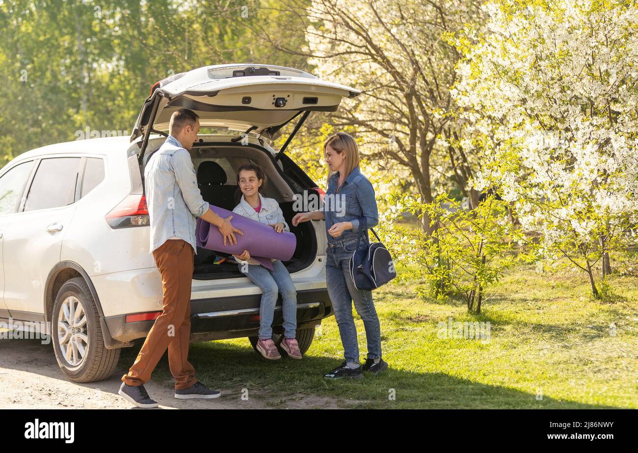 Family with kids sitting in car trunk Stock Photo - Alamy