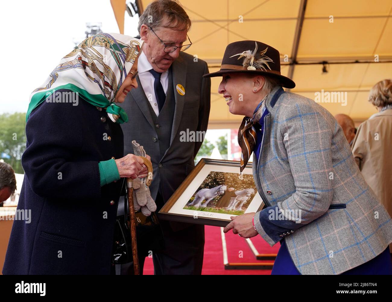 Queen Elizabeth II exchanges photographs with Jane Rawden (right) from ...