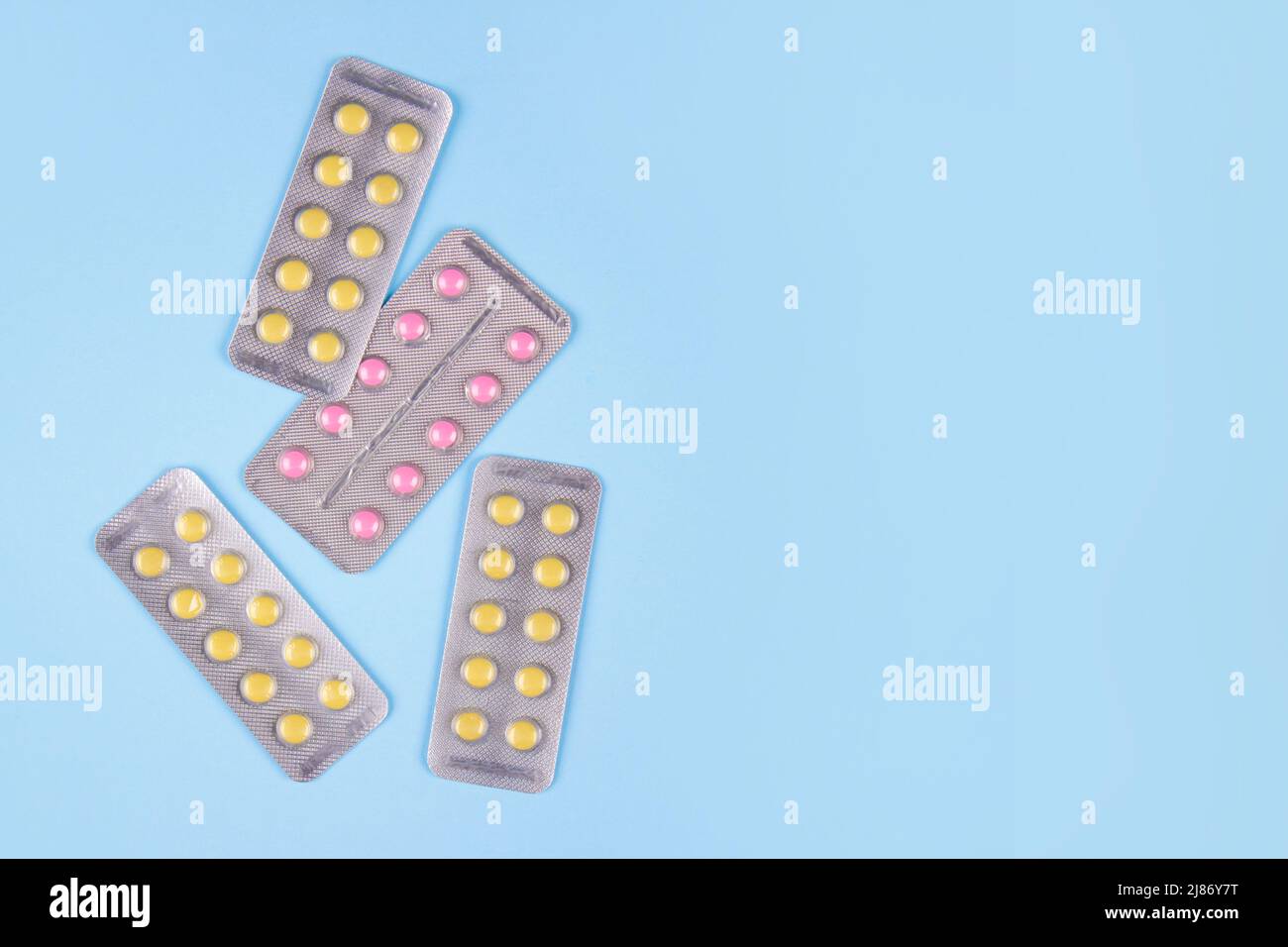 Medicine pills and tablets in blisters on blue background with copy ...