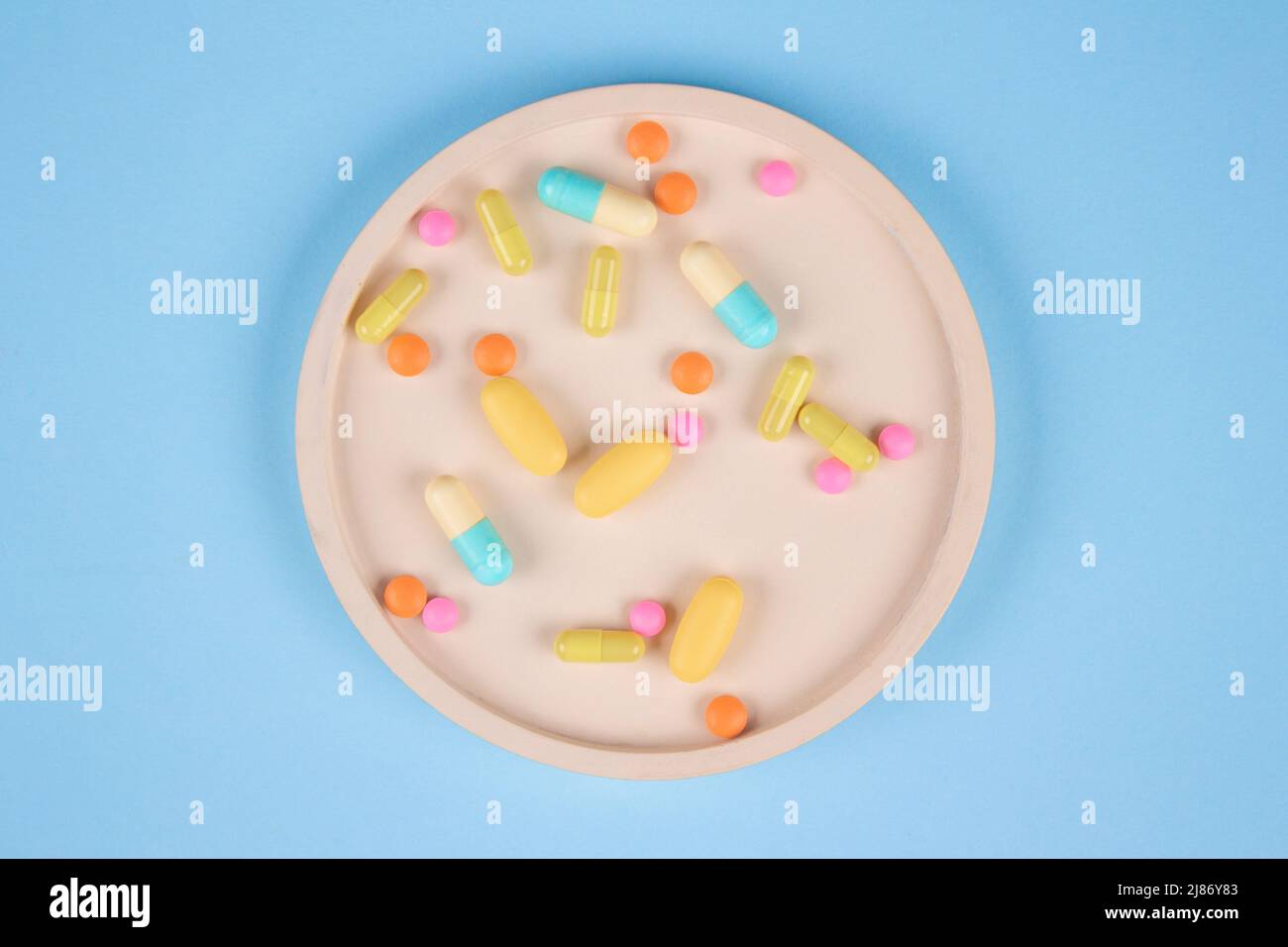 Assorted medicine pills, capsules and tablets on blue background ...