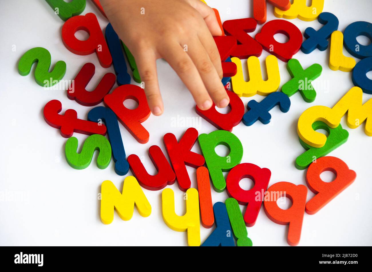 Hand holding wooden color letters on white background. School concept ...