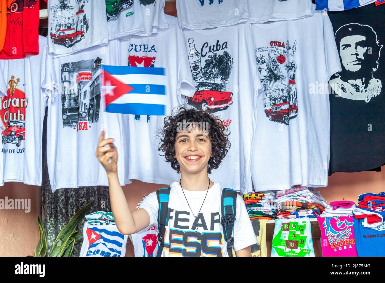 Cuban - Canadian male child waving a small national flag in a souvenir ...