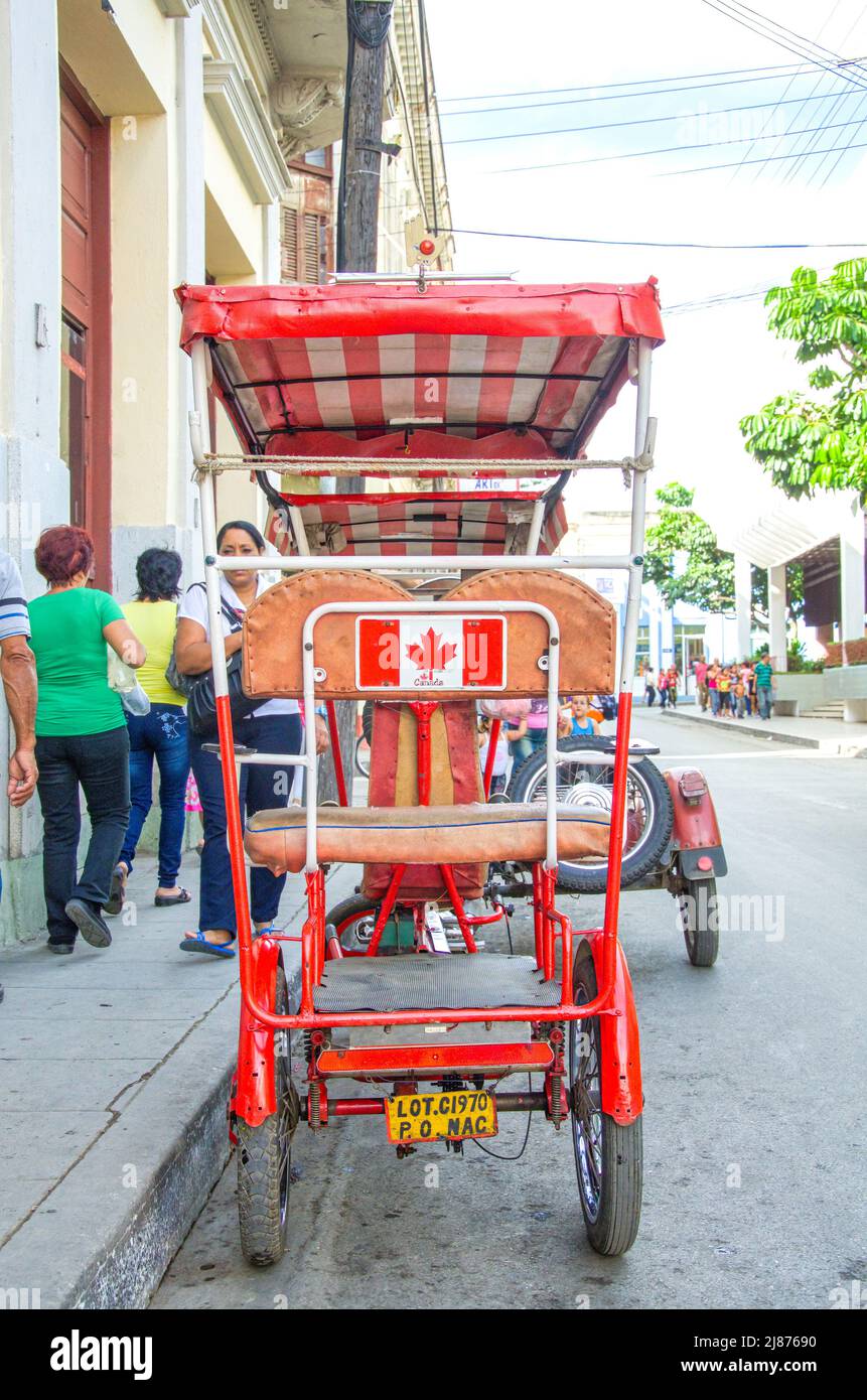 A private bicitaxi or pedicab with a Canadian flag is stationary in the ...