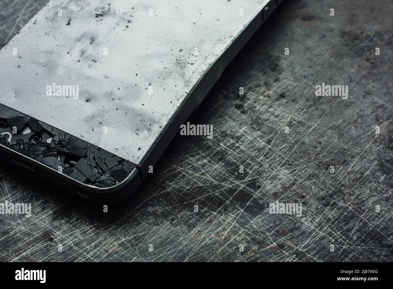 Badly damaged smartphone with bent metal case and broken glass on ...