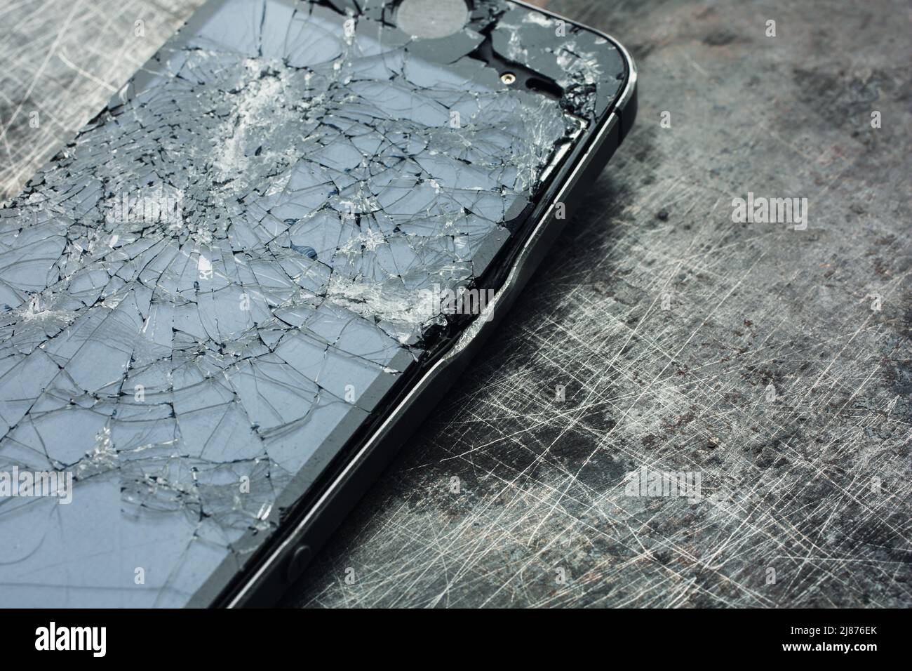 Badly damaged smartphone with bent metal case and broken glass on ...