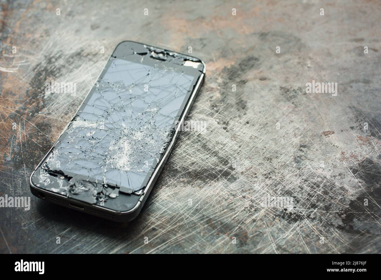 Badly damaged smartphone with bent metal case and broken glass on ...