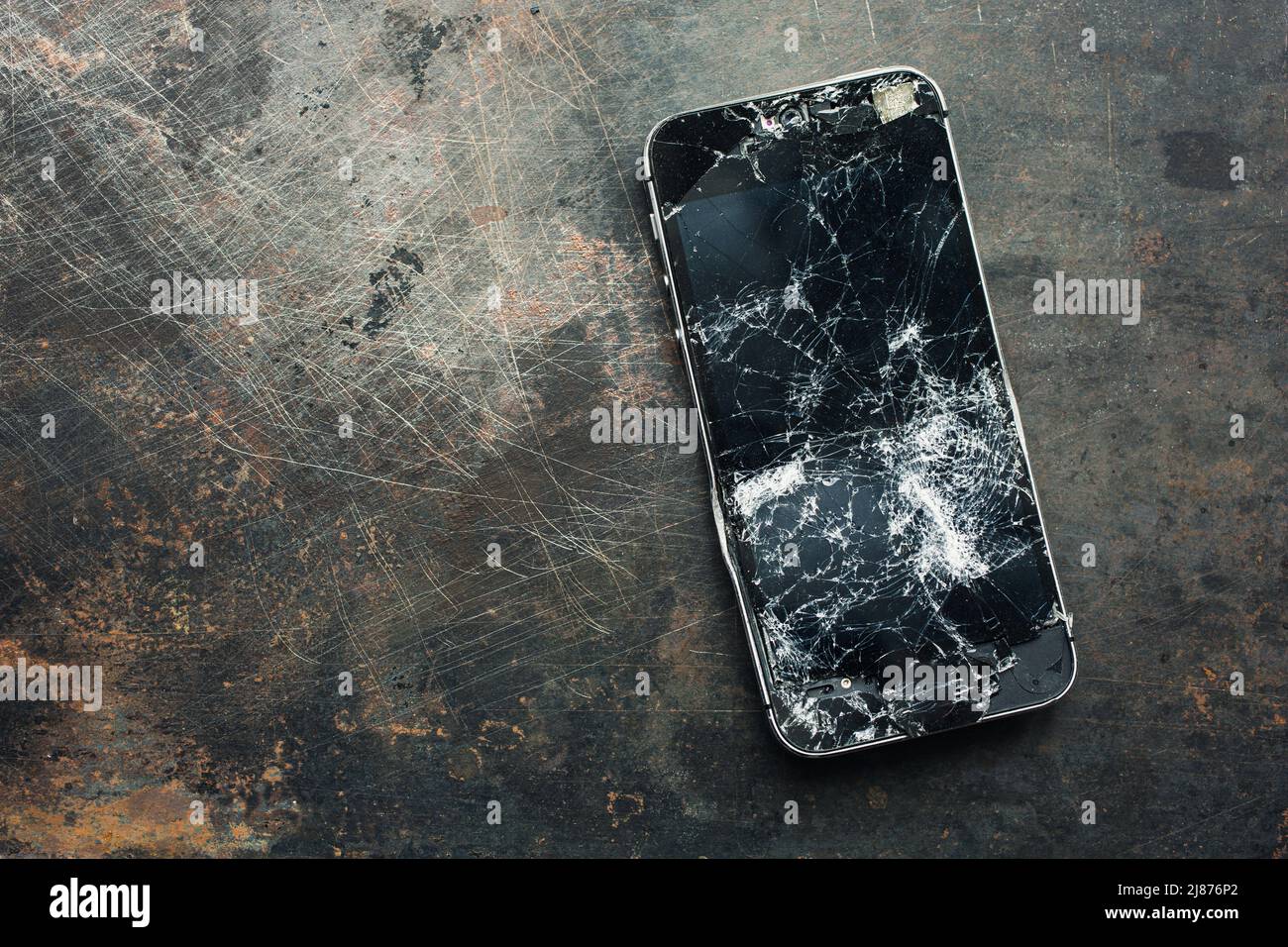 Badly damaged smartphone with bent metal case and broken glass on ...