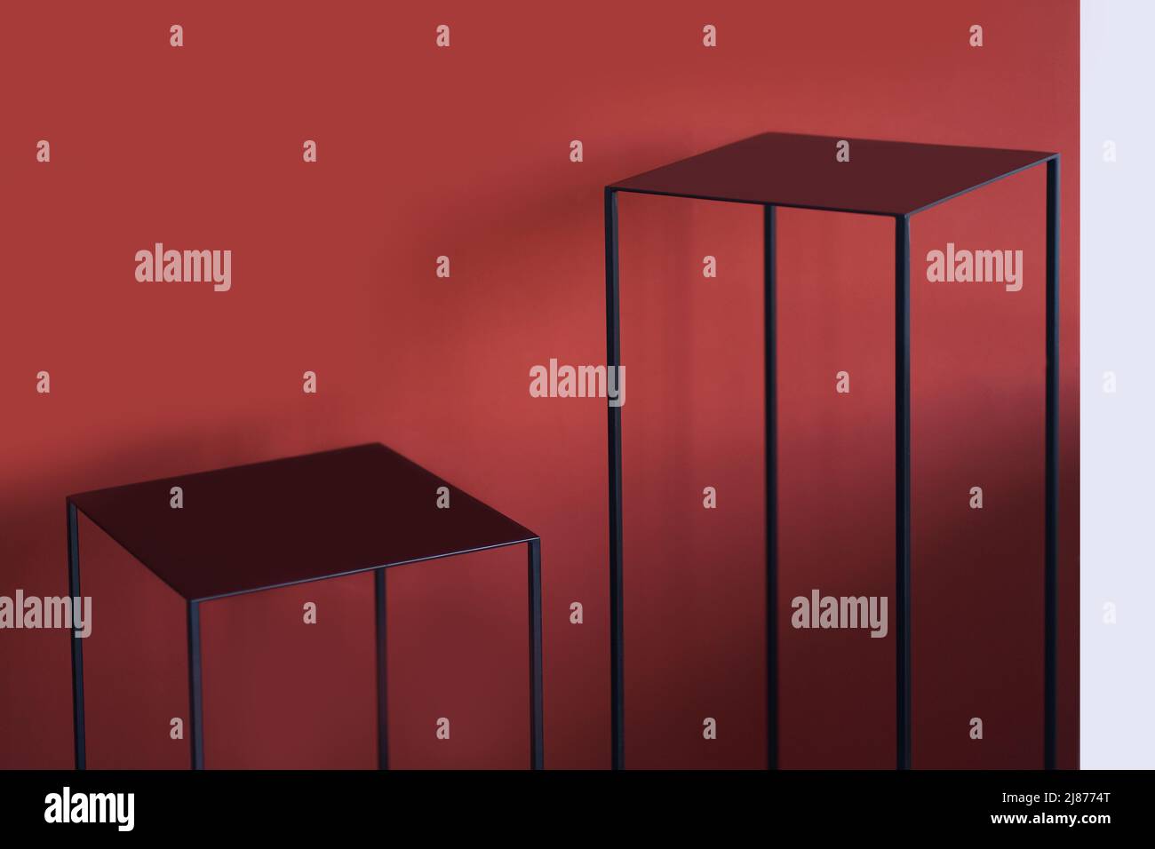 An iron geometric podium on a red background. Stand for product ...