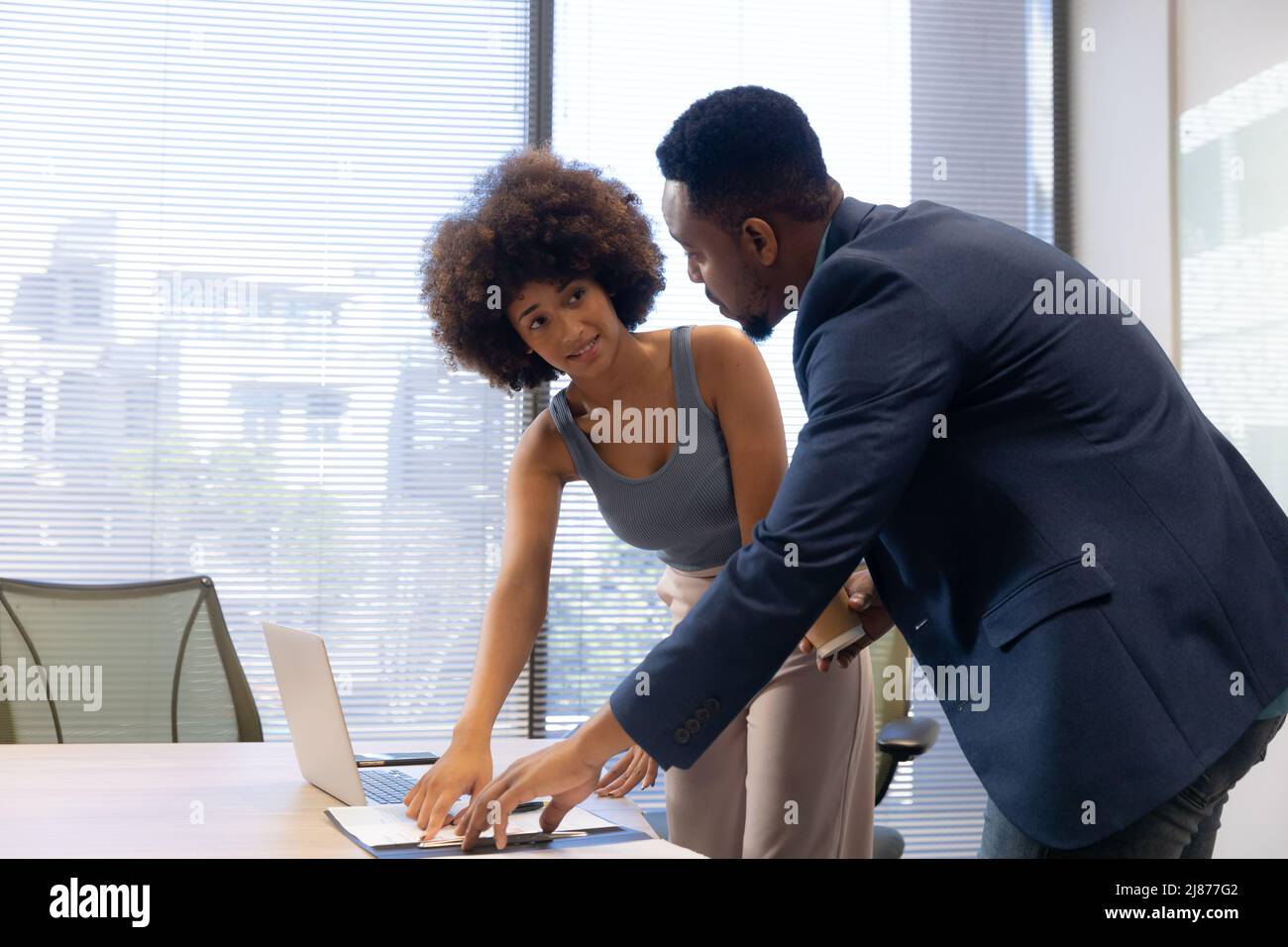 Confident young multiracial colleagues leaning on table while ...