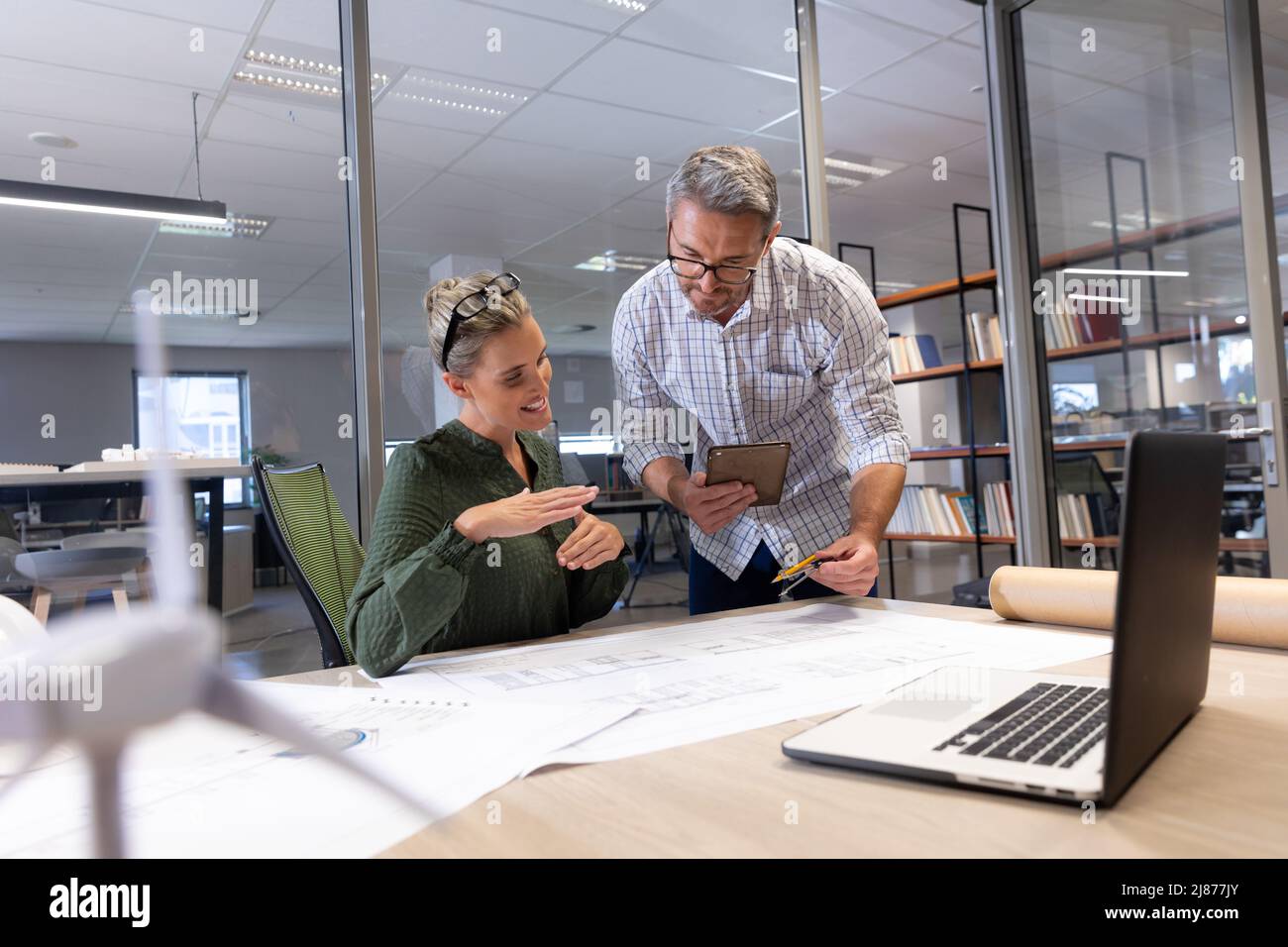 Smiling caucasian engineering colleagues discussing together over ...