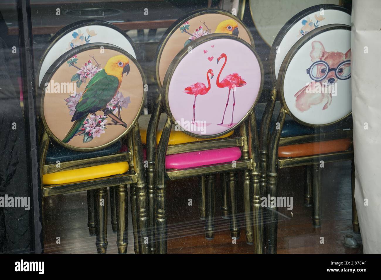 colorful folded painted small round stools in a window in Paris, France ...