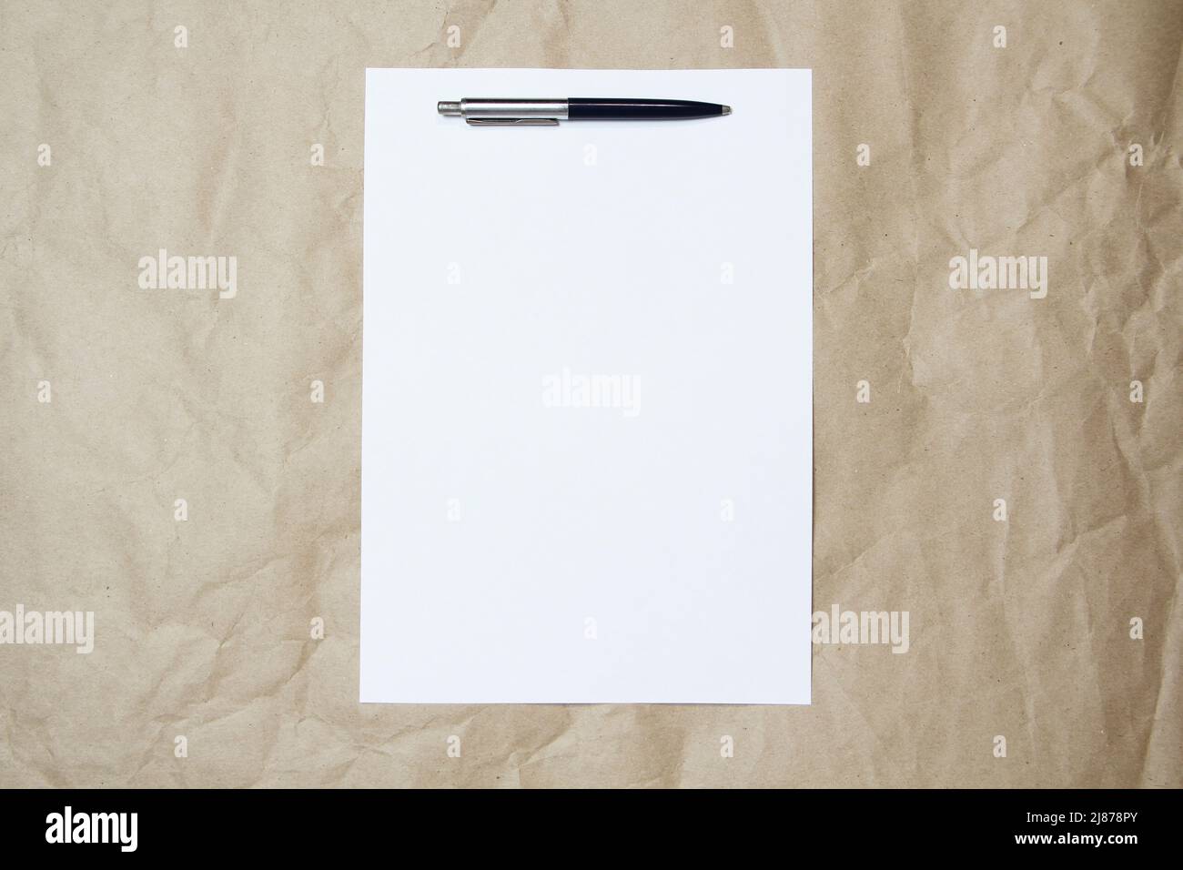 White empty sheet of A4 format with pen on a beige craft paper. Concept ...