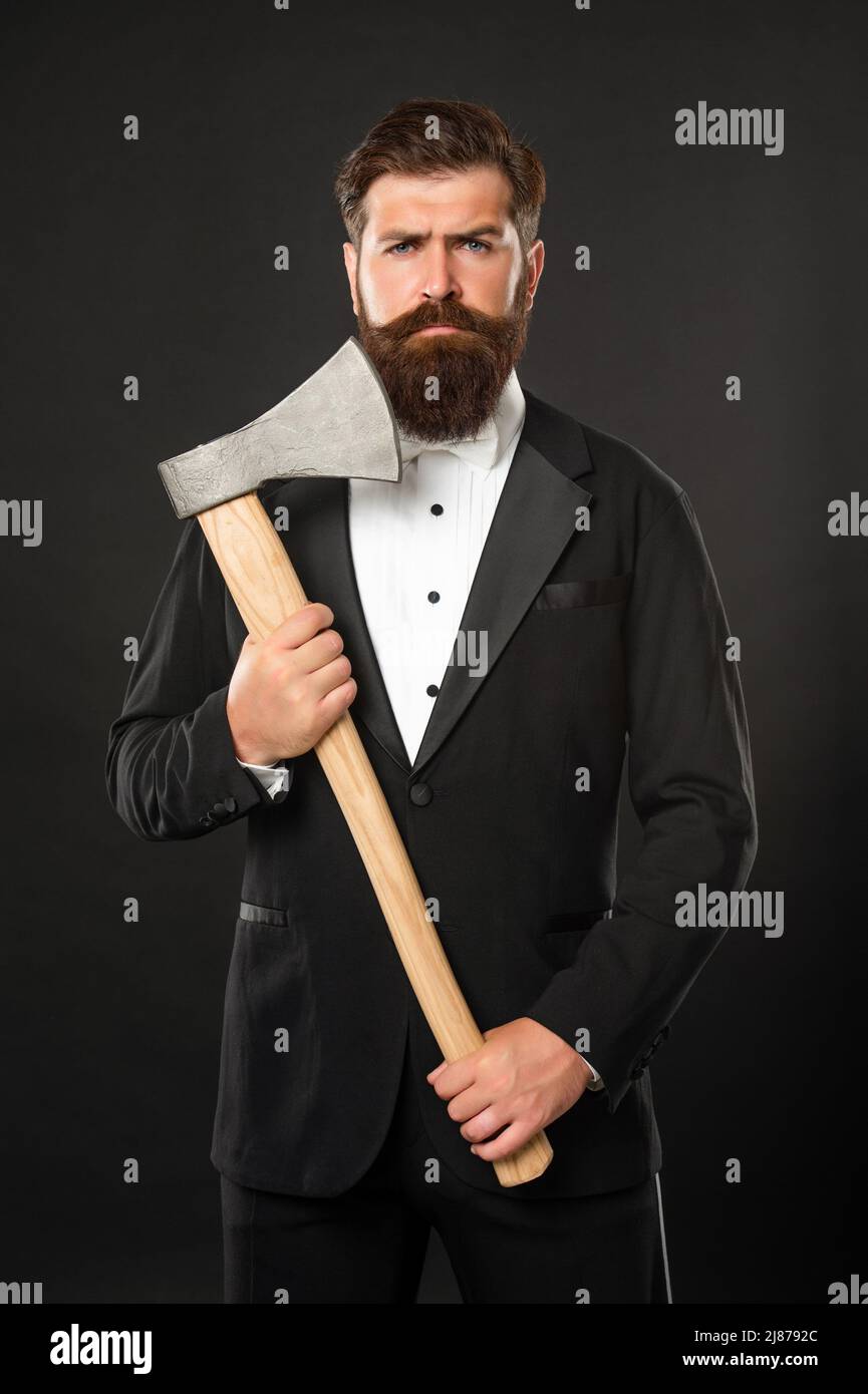 Using axe in place of straight razor. Bearded man in suit hold axe ...