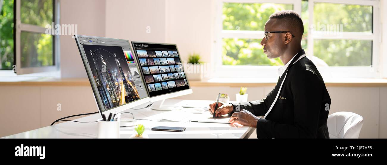 Young Male Designer Editing Photos On Computer In Office Stock Photo ...