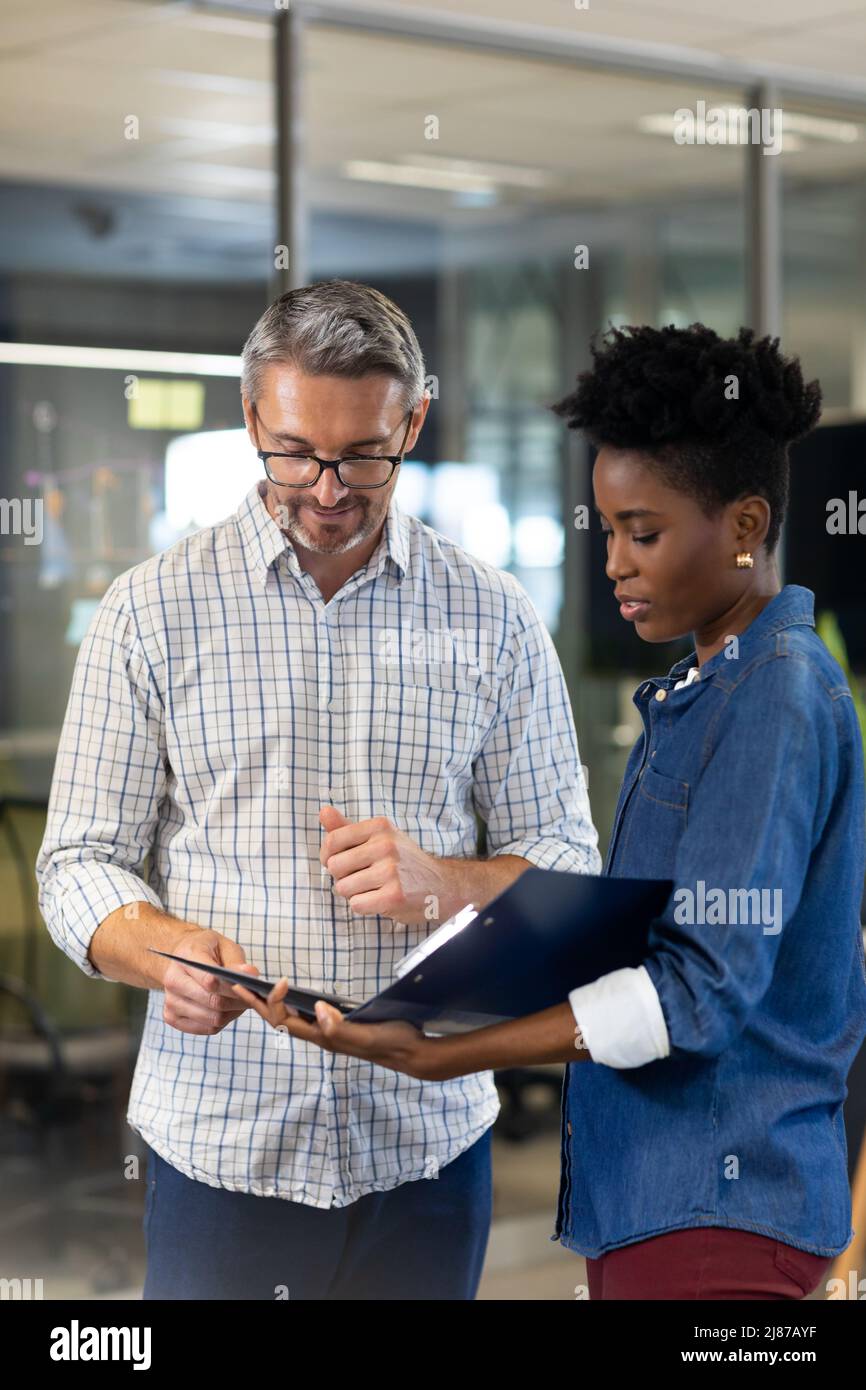Multiracial professionals planning together while discussing over file ...