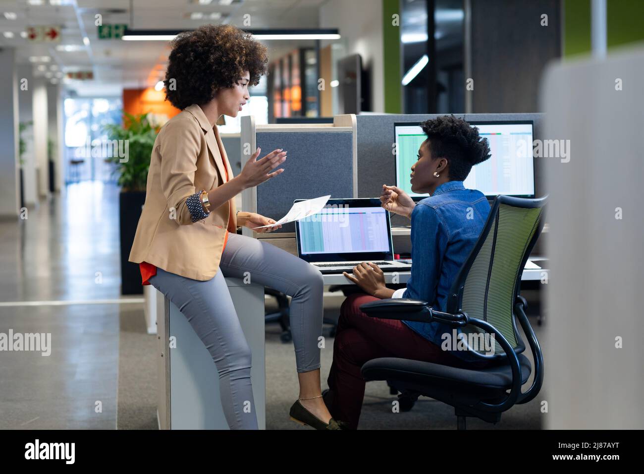 Hispanic businesswoman explanining strategy to african american female ...