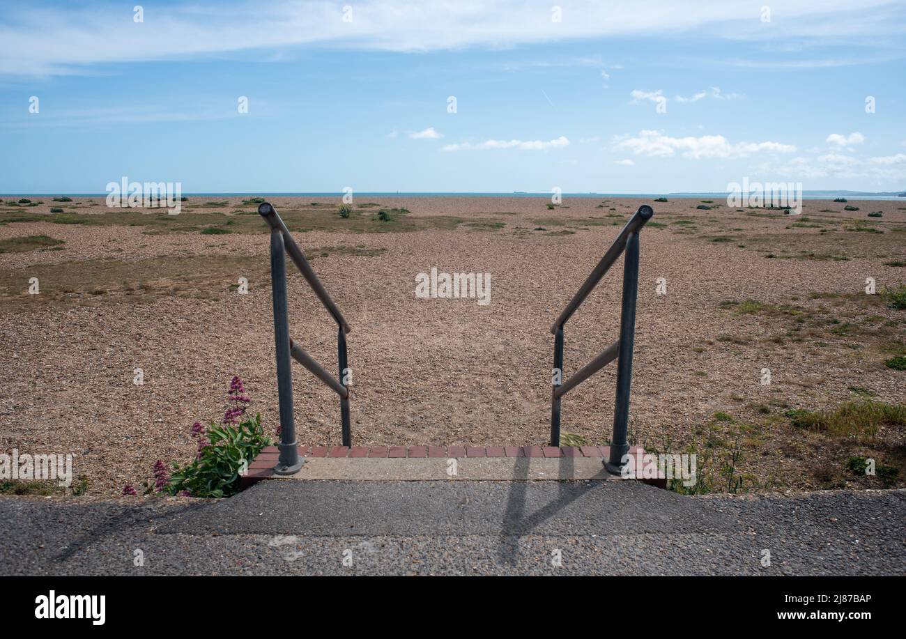 Steps with railings leading down to an open beach Stock Photo - Alamy
