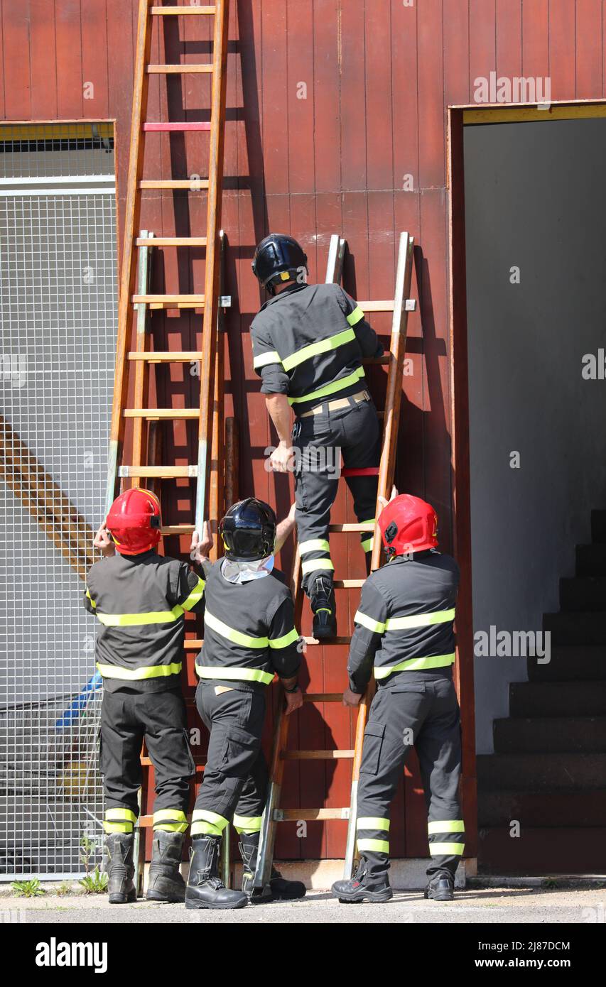 four firefighters in action during the exercise in the fire station ...