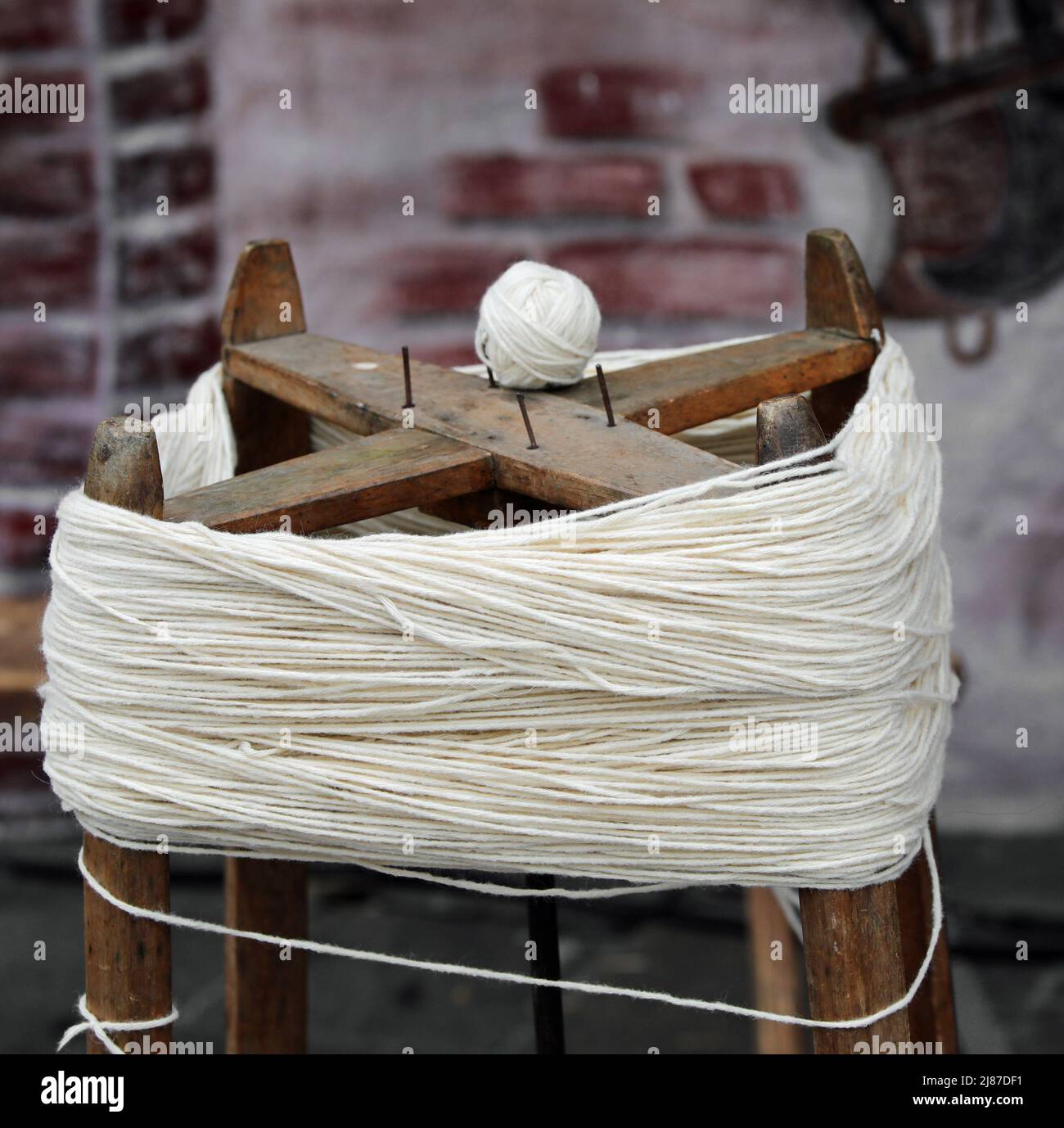 antique wooden spinning wheel also called Swift with the skein of wool ...