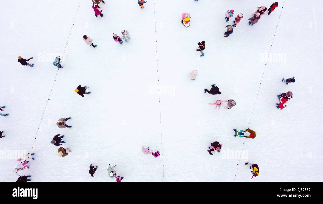 Top view of people skating on a large open-air ice rink on a winter day ...
