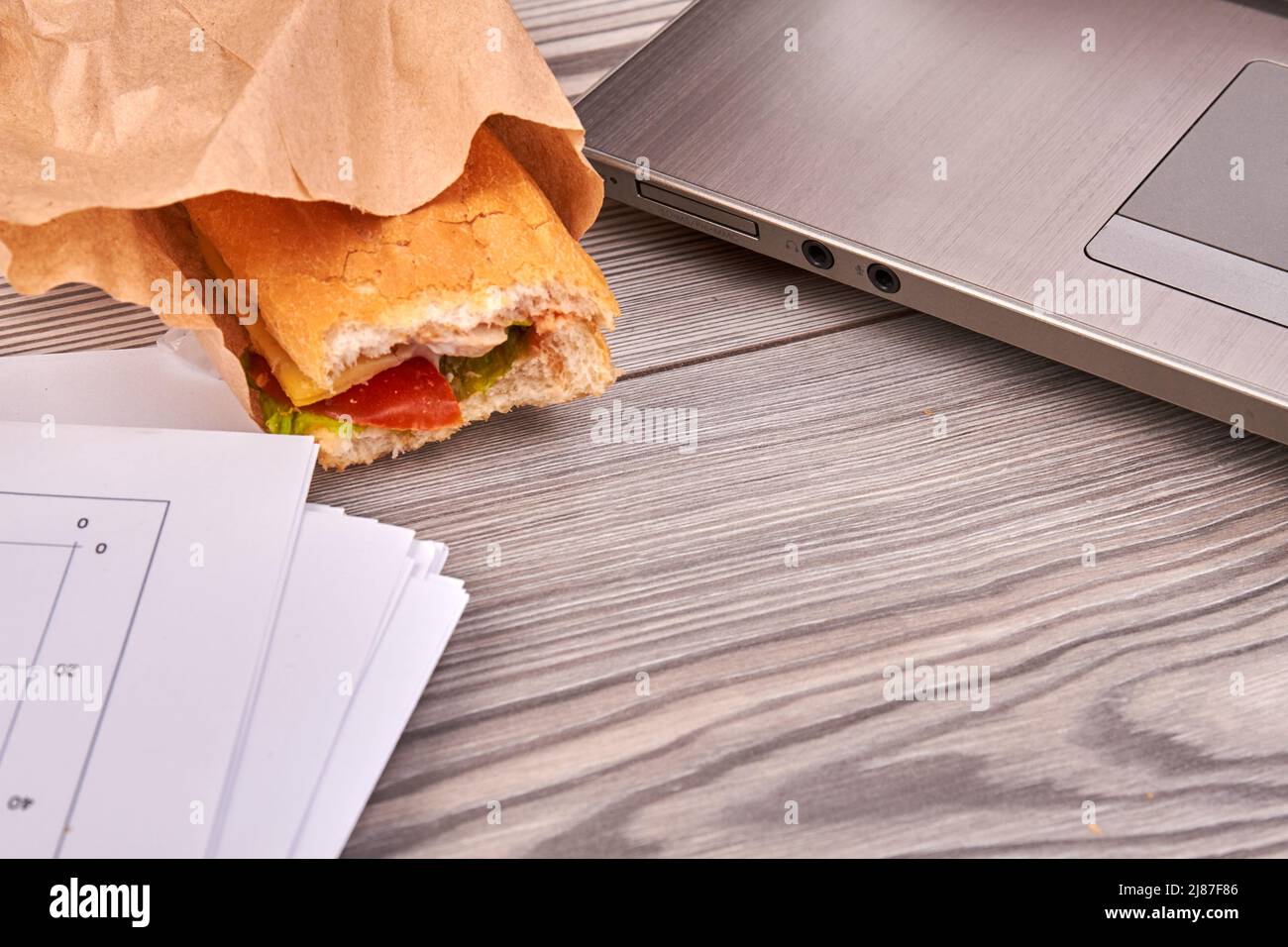 Sandwich and laptop on the office desk. Gray wood background Stock ...