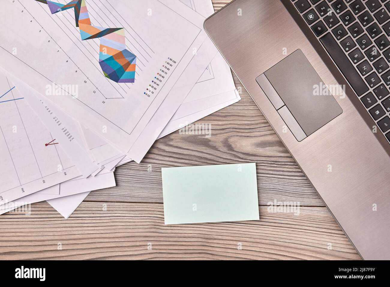 Blank note paper for copy space with charts and laptop. Top view flat ...