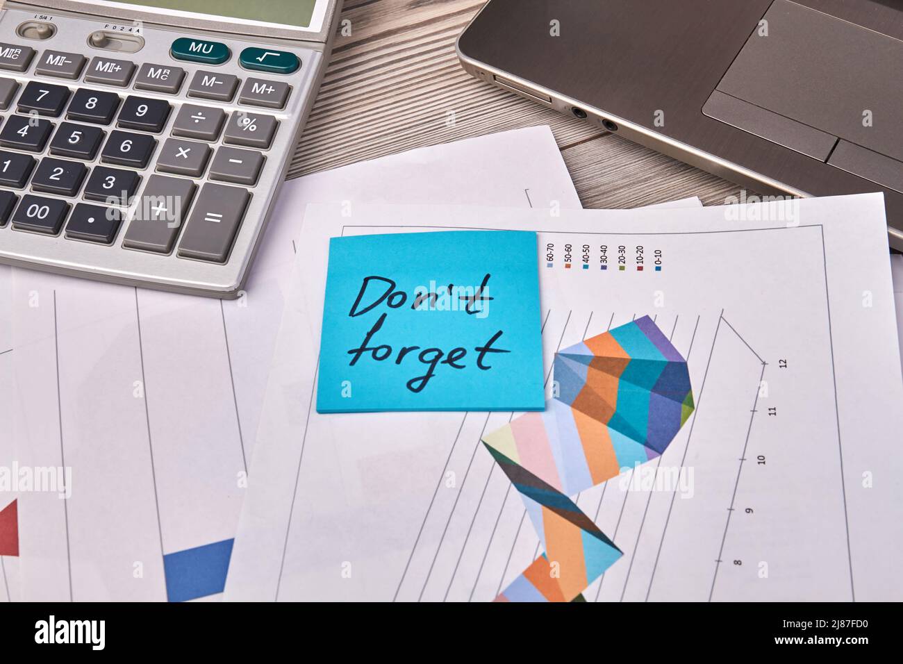 Sticky note with dont forget handwriting on the office work desk ...