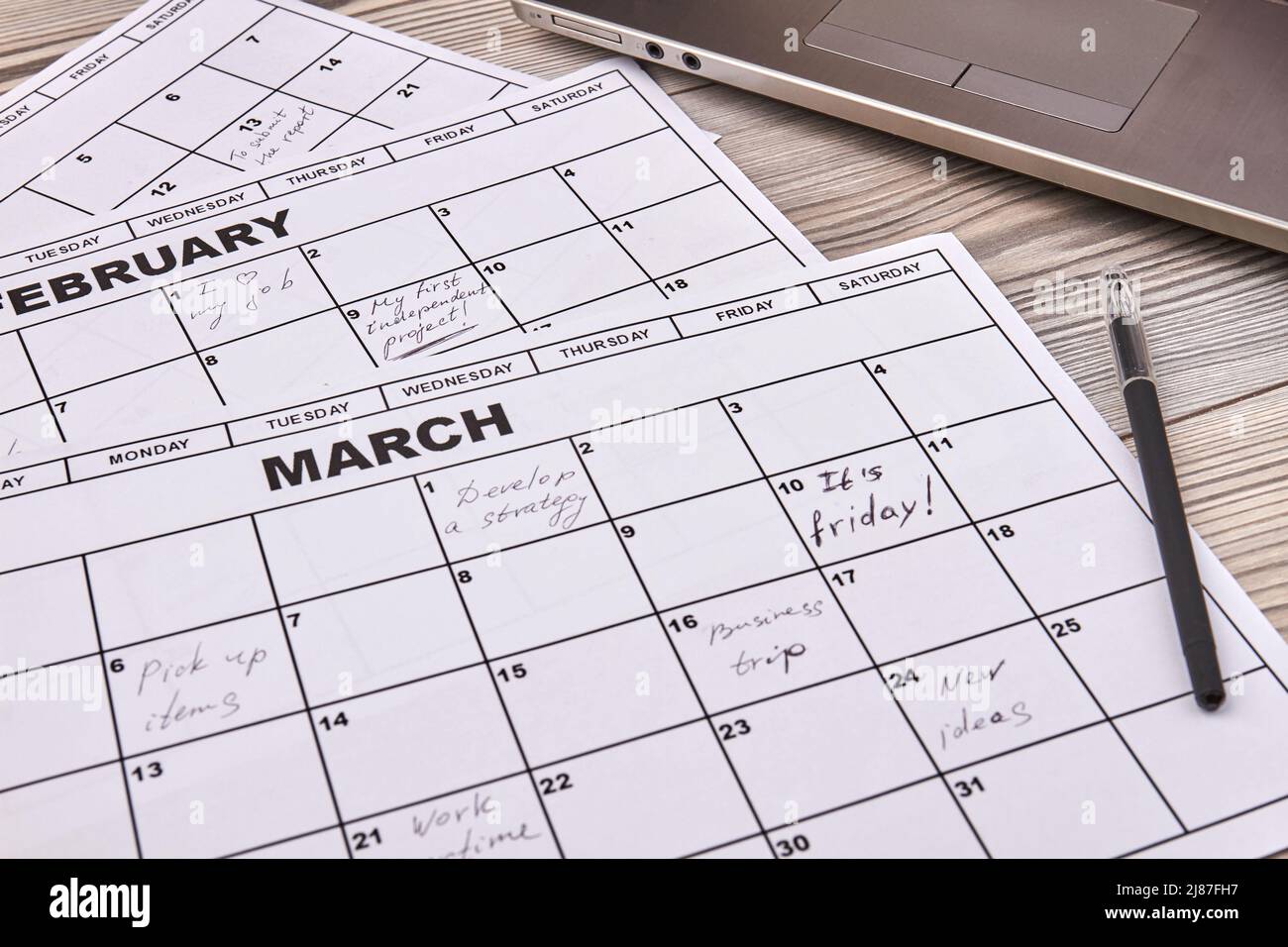 Paper month calendar with pen and laptop. White desk background Stock ...