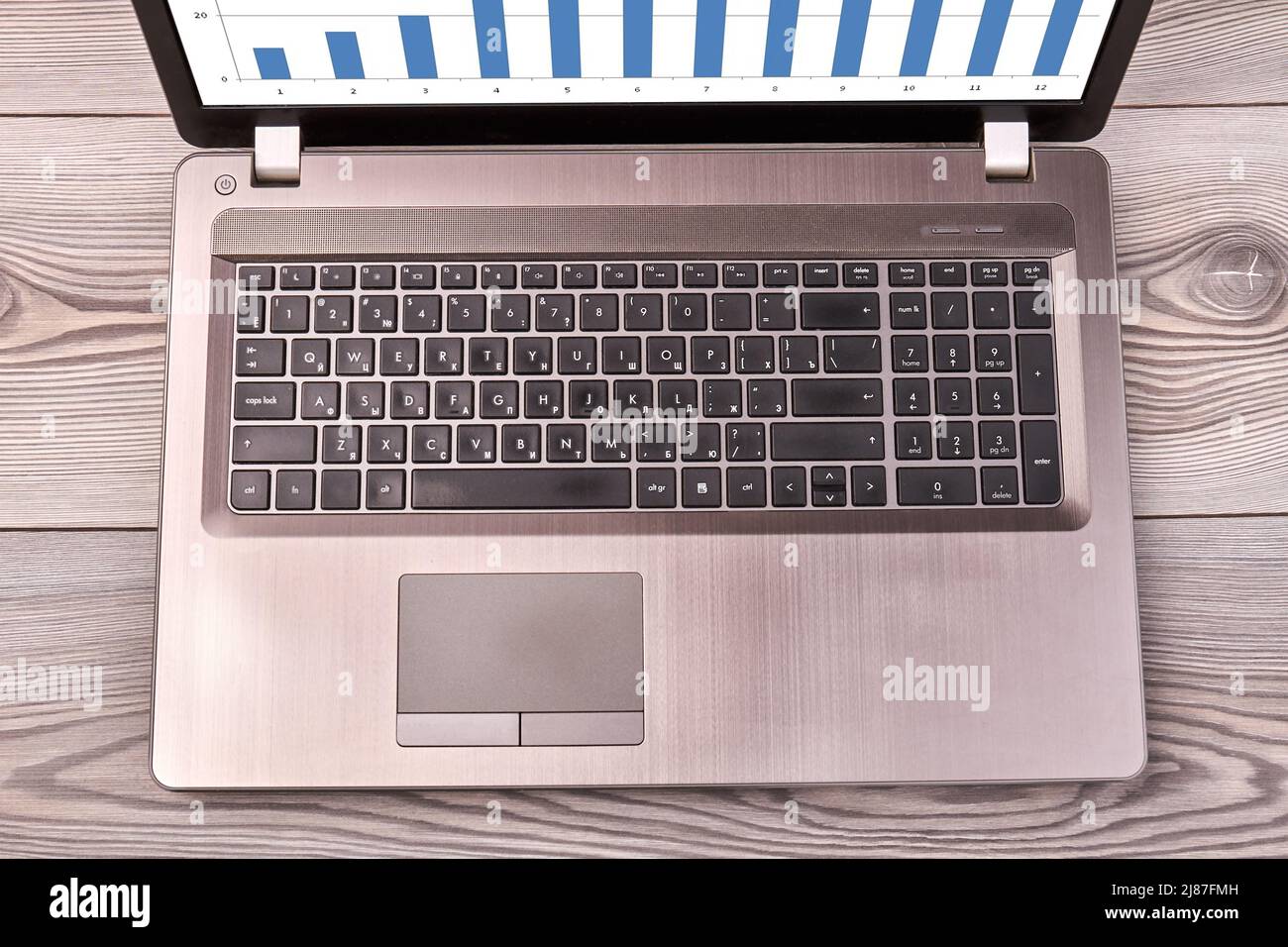 Modern metallic laptop on wooden desk top view. Gray desk background ...