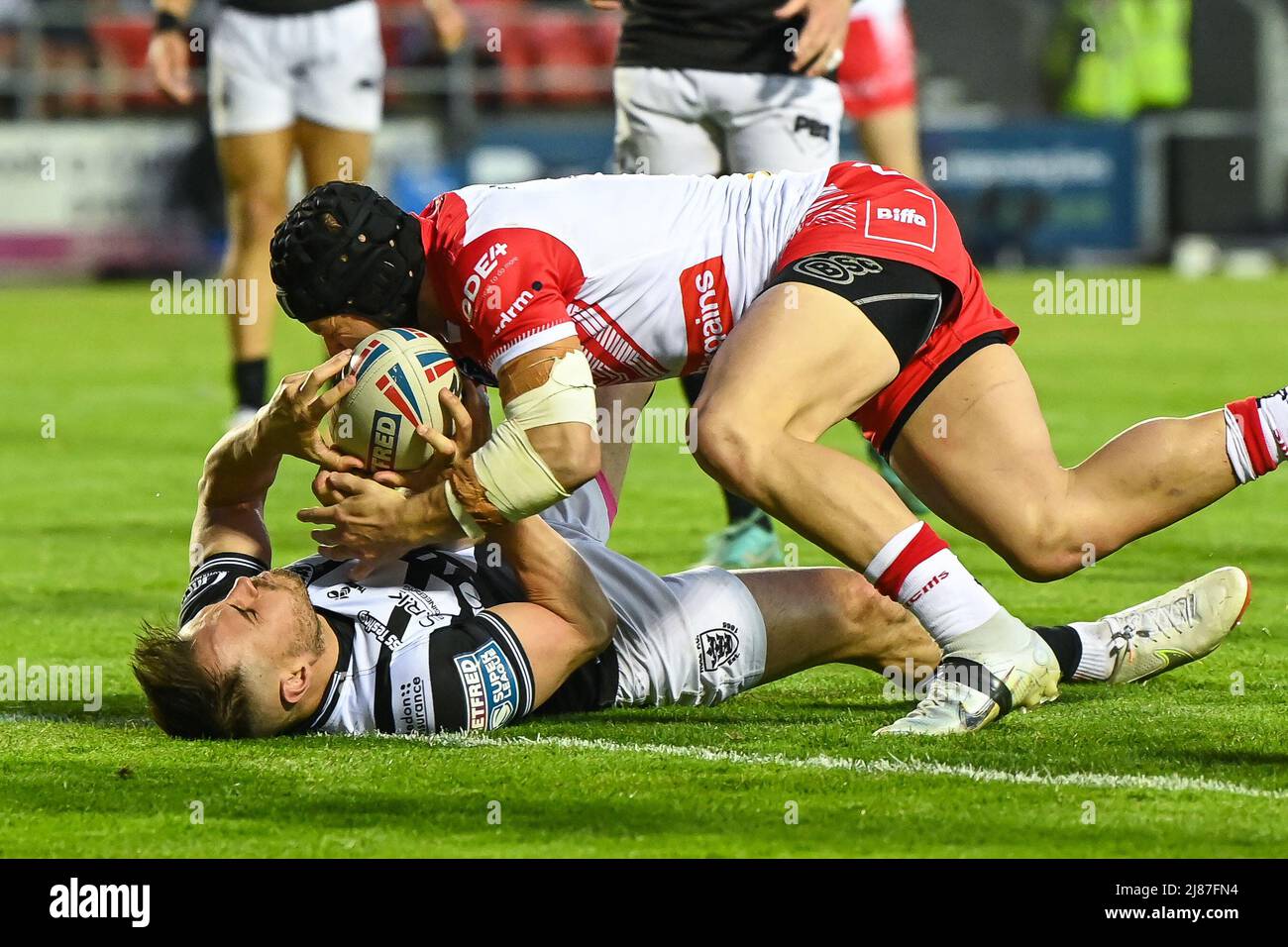 Josh Reynolds (6) of Hull FC is held up by Jonny Lomax #6 of St Helens ...