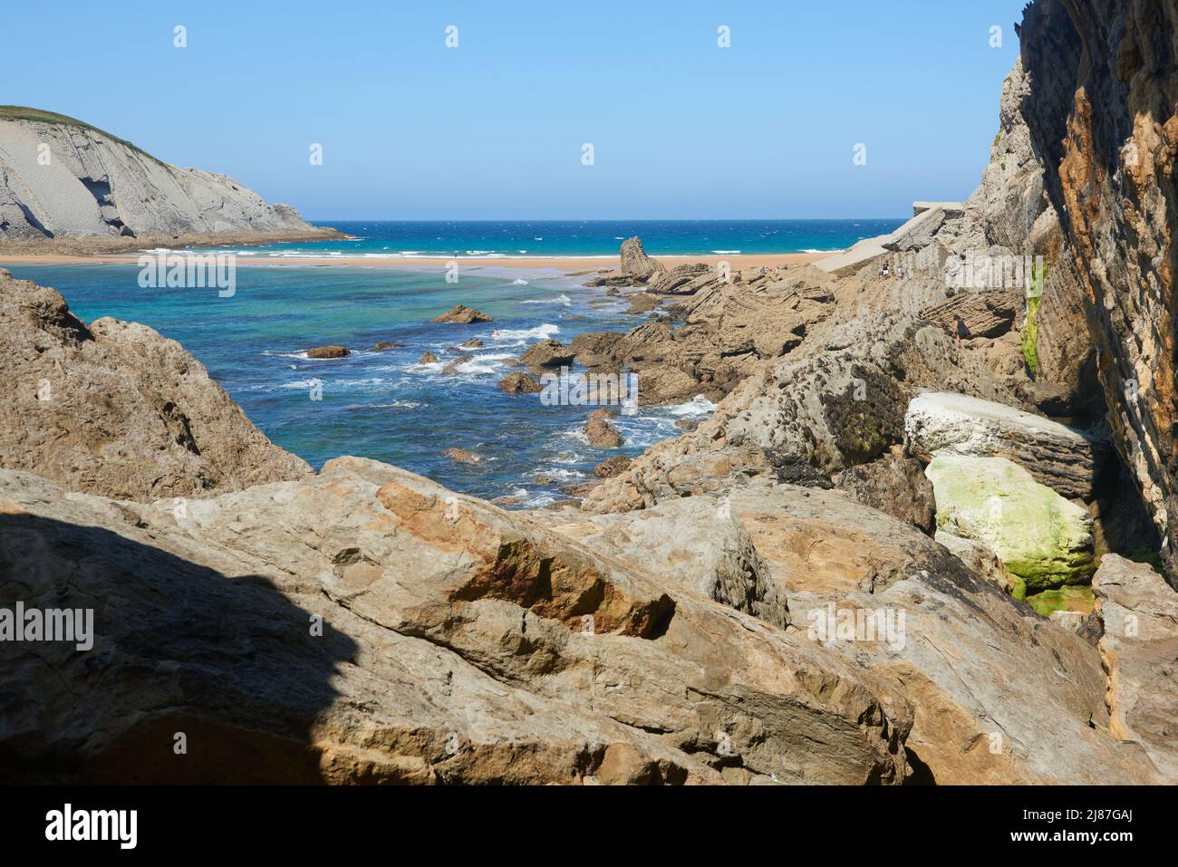 Steep cliffs next to a calm sea with a beautiful blue sky Stock Photo ...