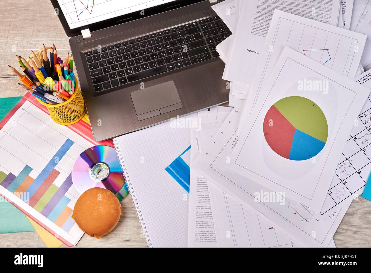 Top view laptop and many work papers with statistic diagrams. Office ...