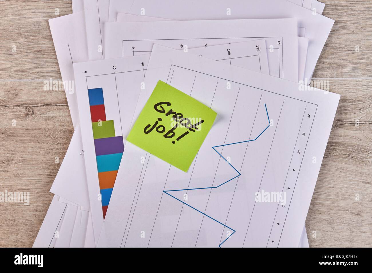 Sticky note with great job handwriting and charts with statistic. White ...