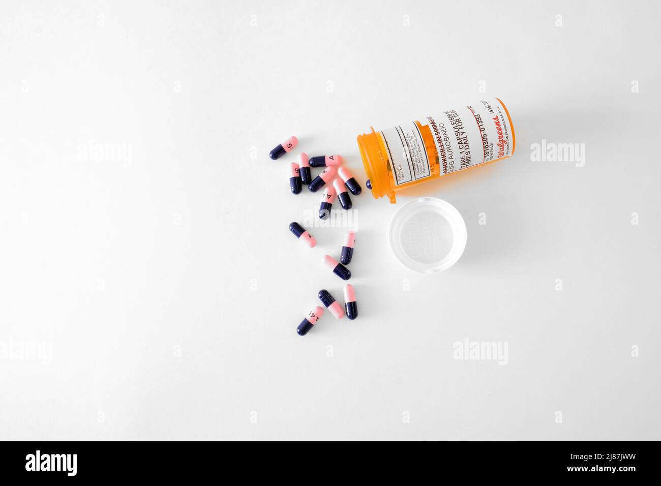Amoxicillin capsules on a white background; antibiotic used to treat ...