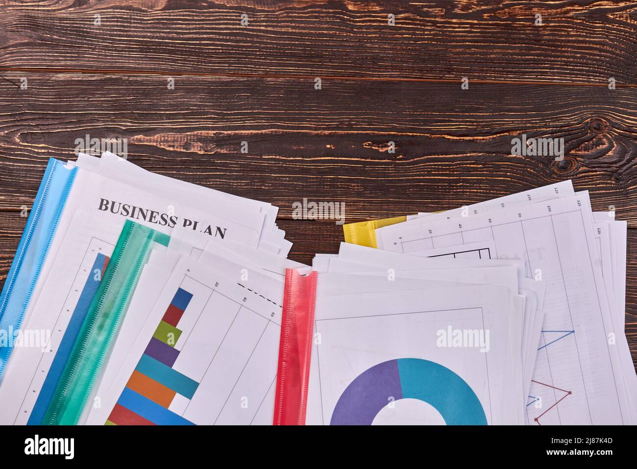 Paper sheets with business graphs and charts. Brown wooden desk ...