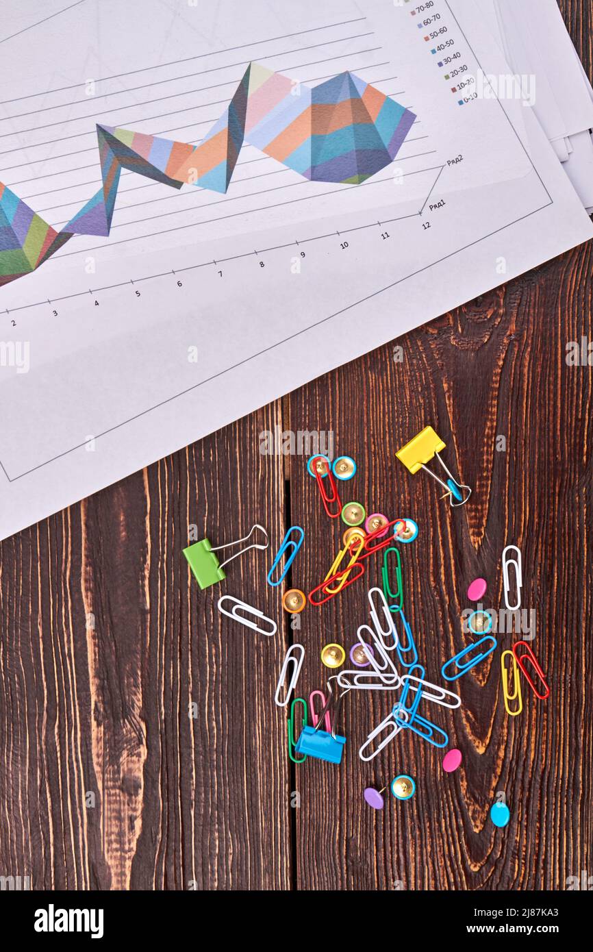 Top view pile of paper clips with work papers. Brown wooden desk Stock ...