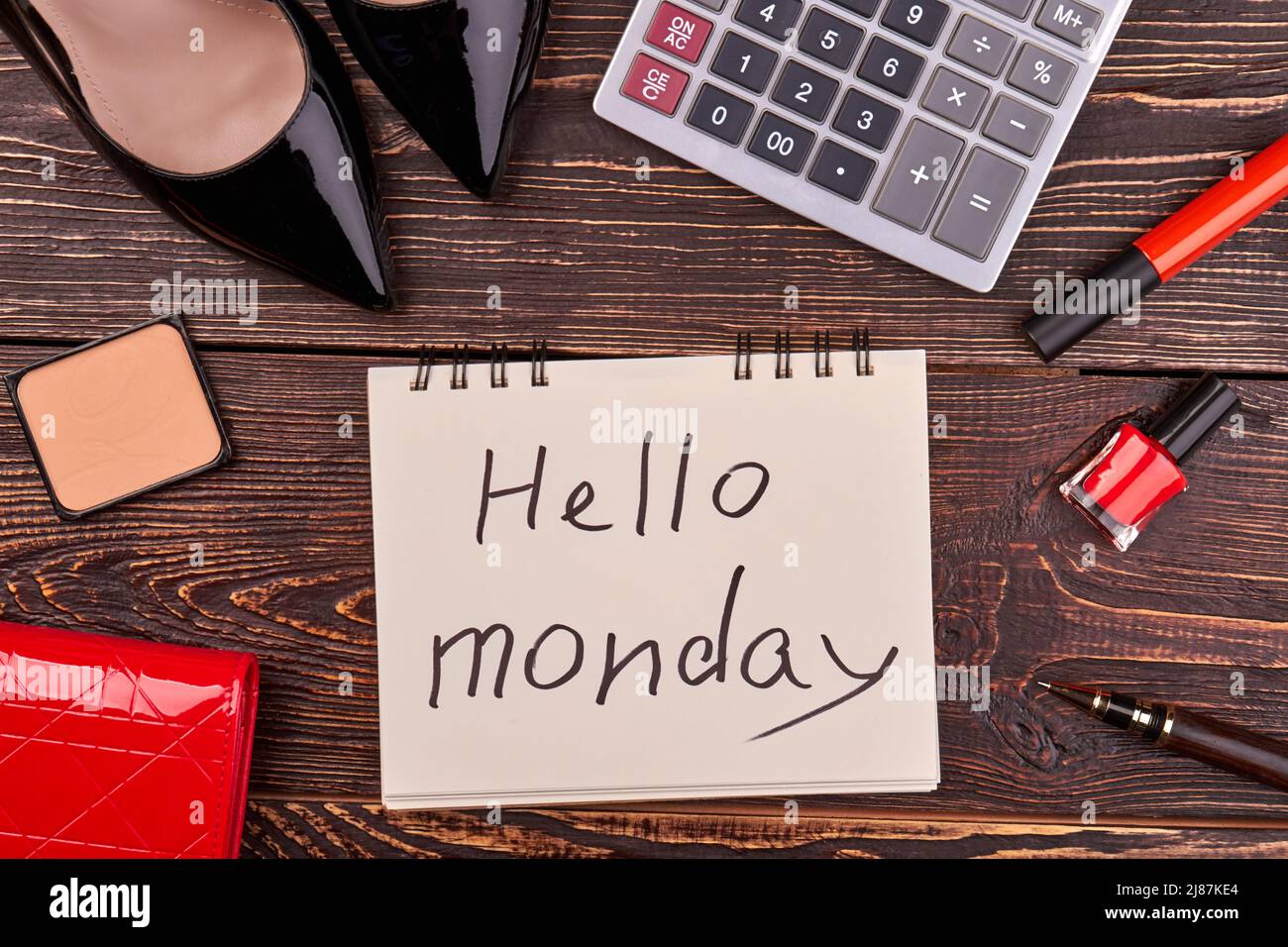 Top view flat lay note with hello monday handwriting. Brown wooden desk ...