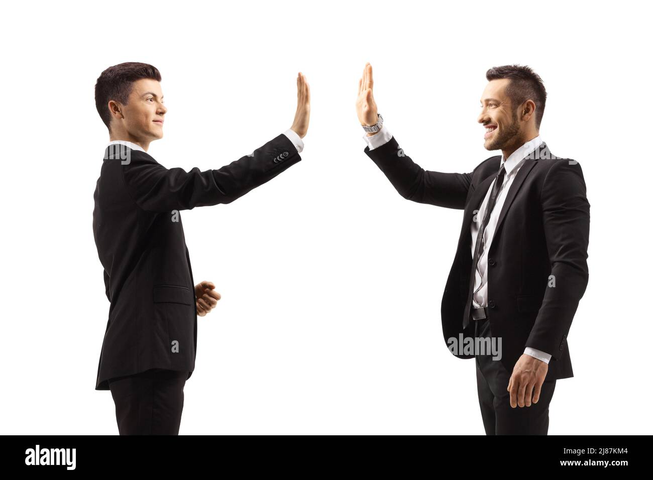 Young men in suits gesturing high-five isolated on white background ...