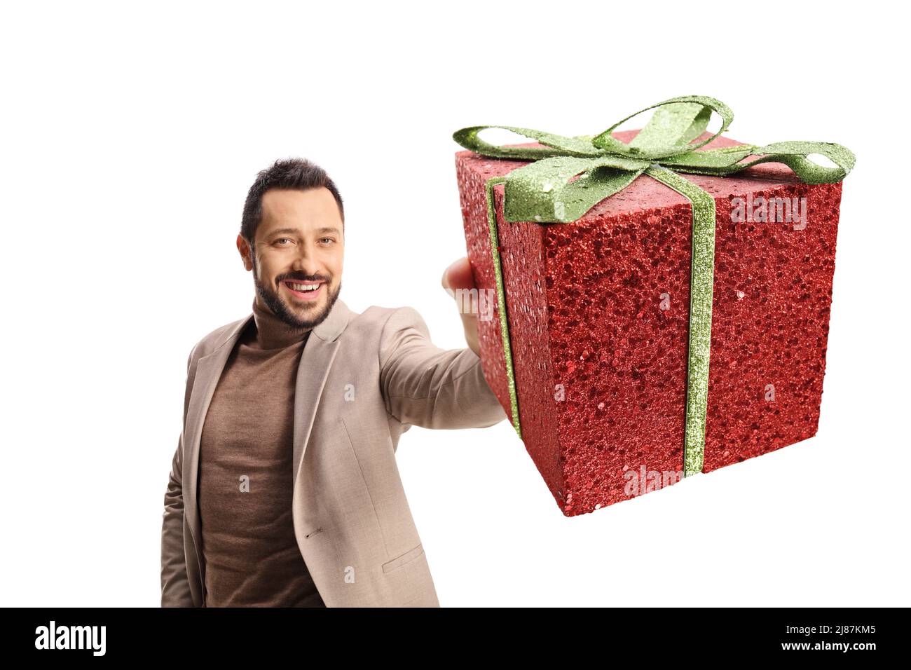 Young man holding a glittery red present box isolated on white ...