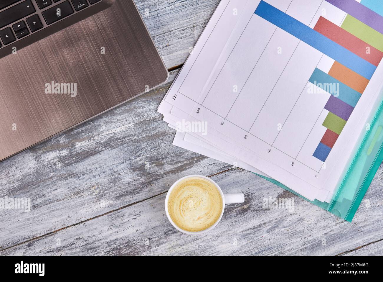 Top view laptop with coffee and papers with statistic. Wooden workdesk ...