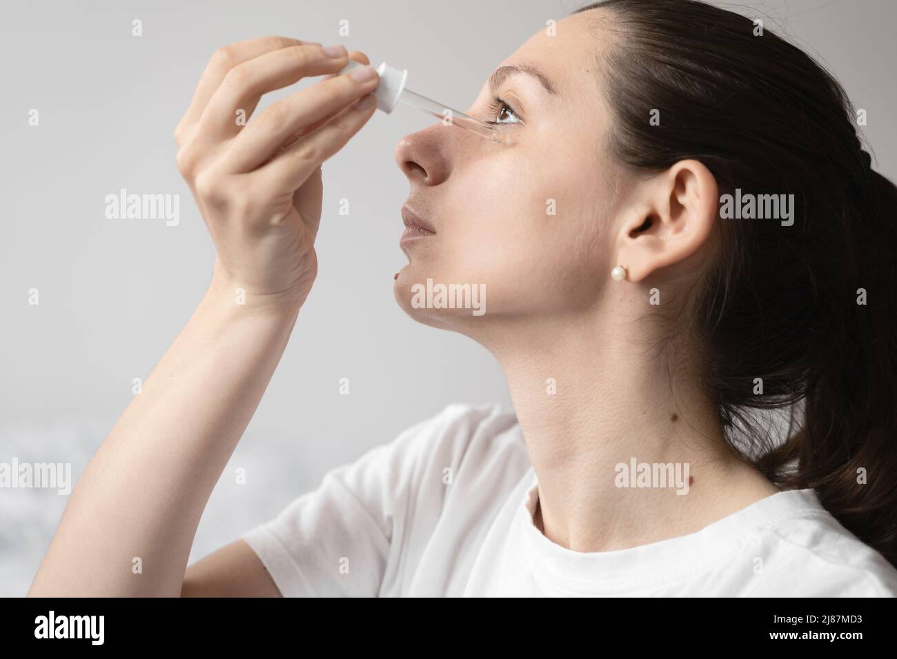 Close up of white woman hand applying oil of essential oil or serum for ...