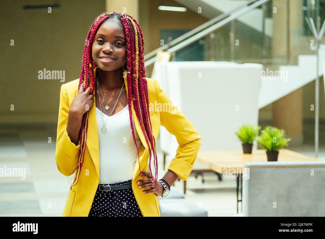 happy, afro american woman in a stylish yellow jacket and multi-colored ...