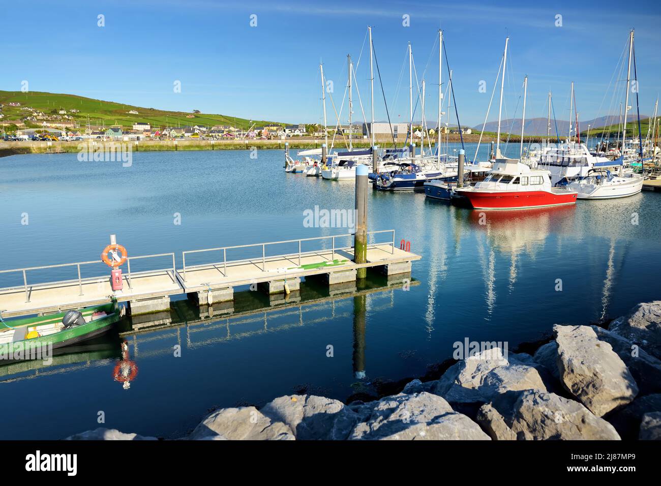 Colorful fishing boats and yachts at the harbor of Dingle town on the ...