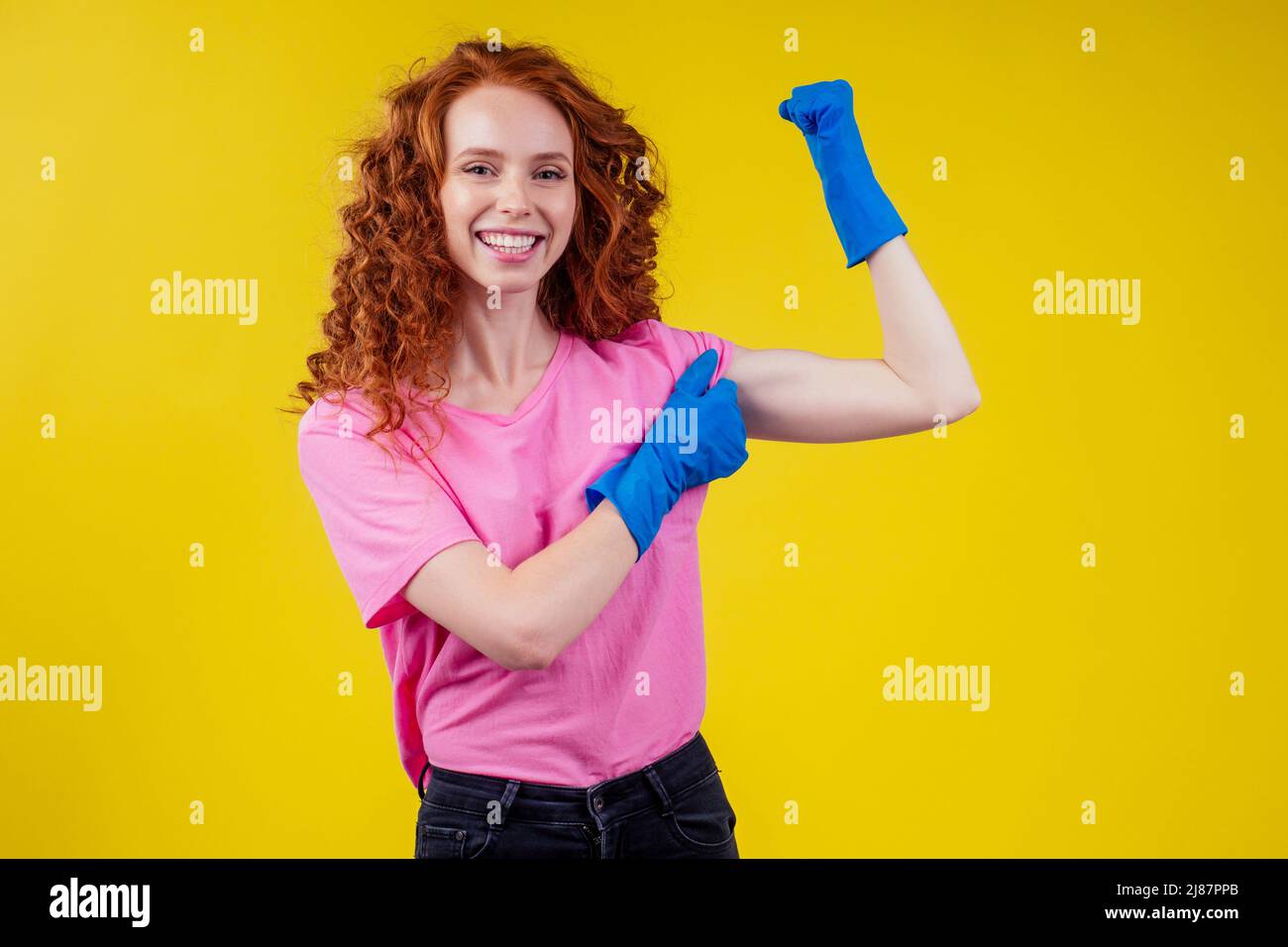 redhaired curly ginger woman showing training hands muscles in studio ...