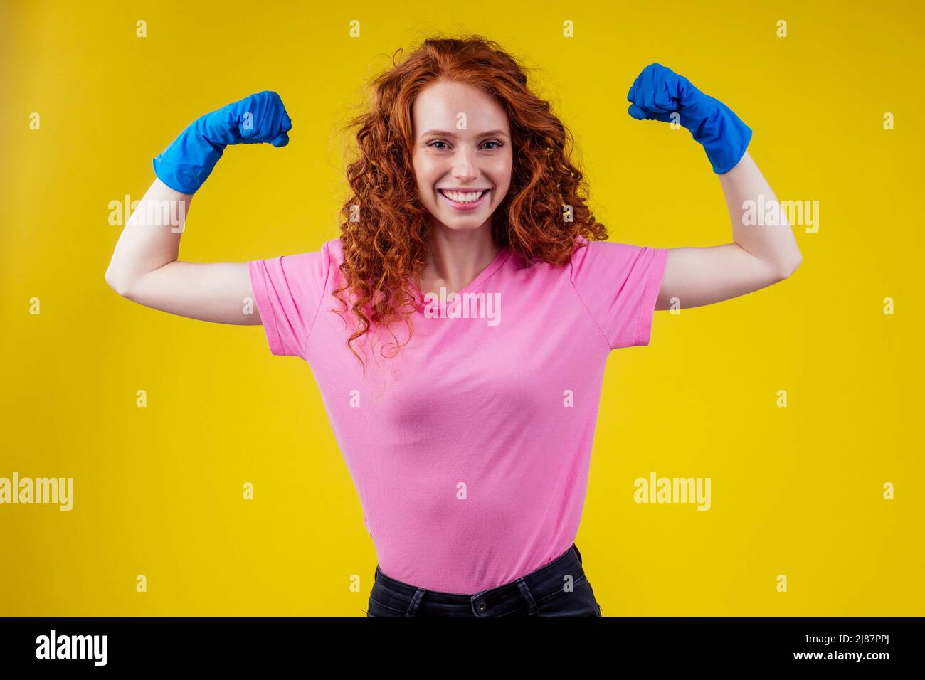 redhaired curly ginger woman showing training hands muscles in studio ...