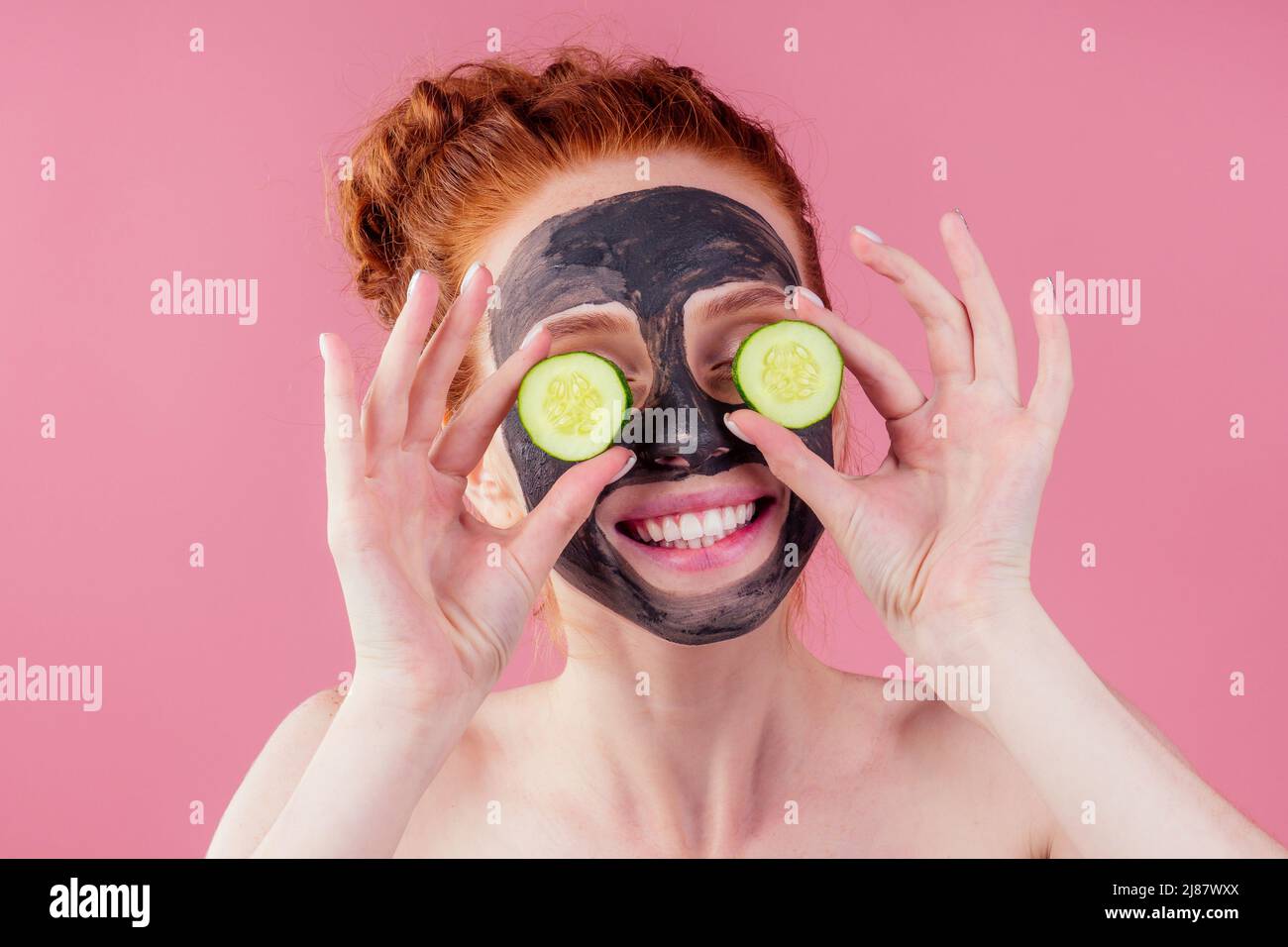 redhead ginger female with cucumber and clay mask on her pretty face ...