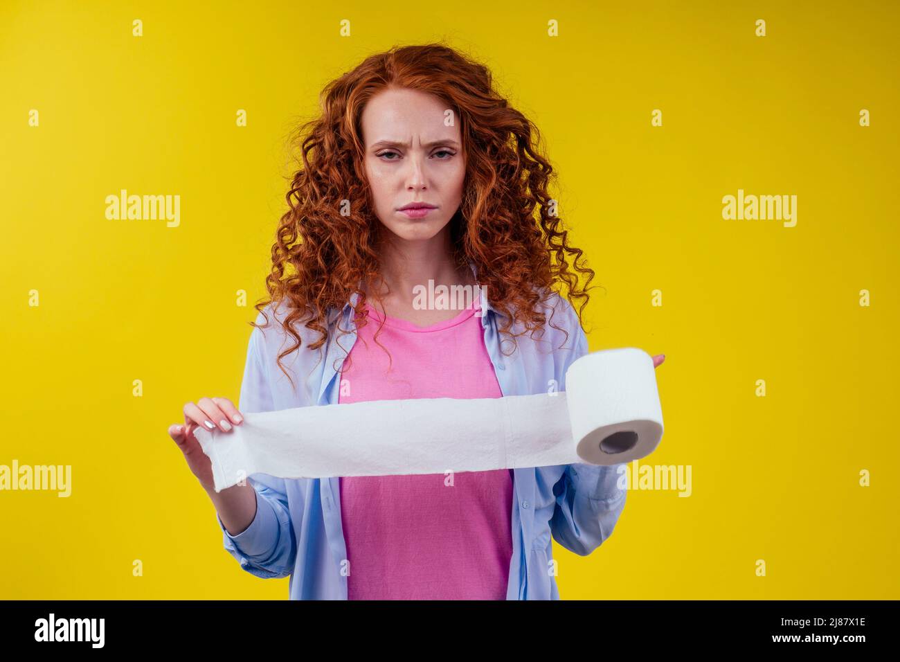 Beautiful Curly Redhead Ginger Woman Holding Toilet Paper Roll On Yellow Color Background Stock
