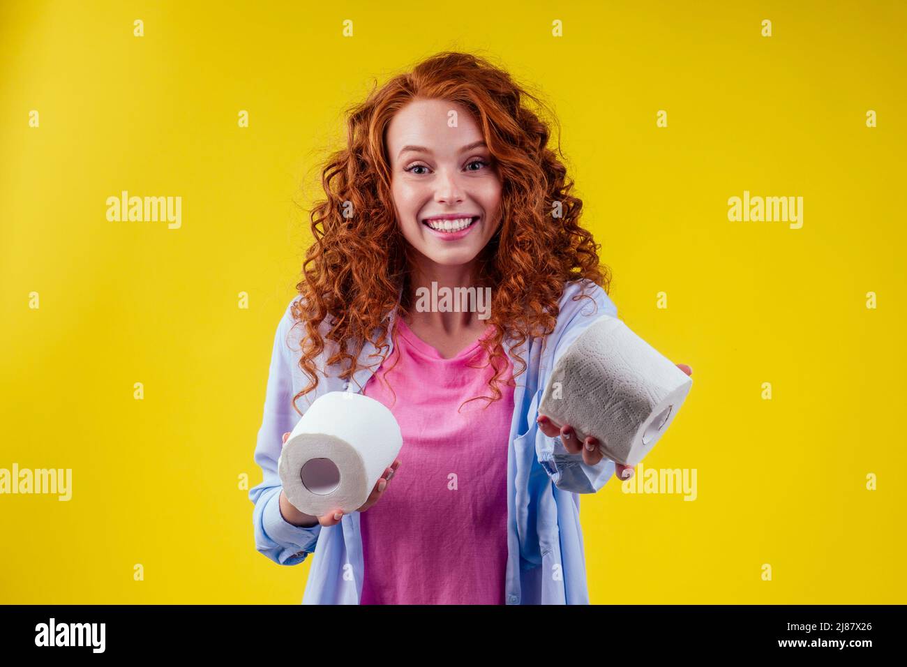 Beautiful curly redhead ginger woman choosing eco toilet paper roll on ...
