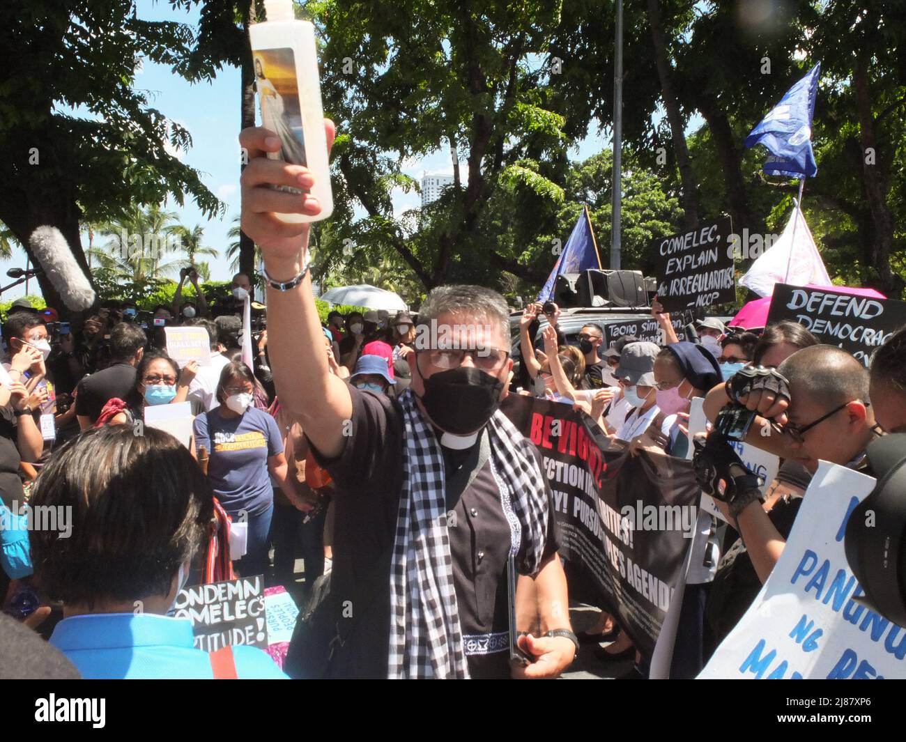 A catholic priest blesses the protesters with holy water after the ...